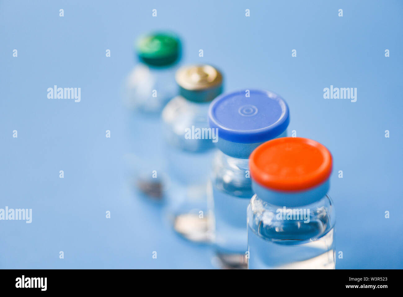 Medicine bottles glass for syringe injection needle on blue background ...
