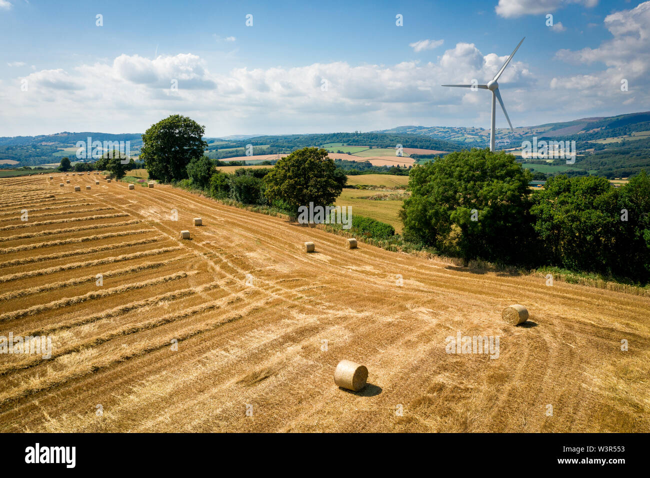 Aerial view of Straw bales with a wind turbine on farmland in Wales UK ...