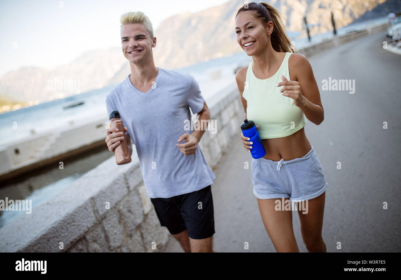 Happy fit people couple jogging and running outdoors Stock Photo - Alamy