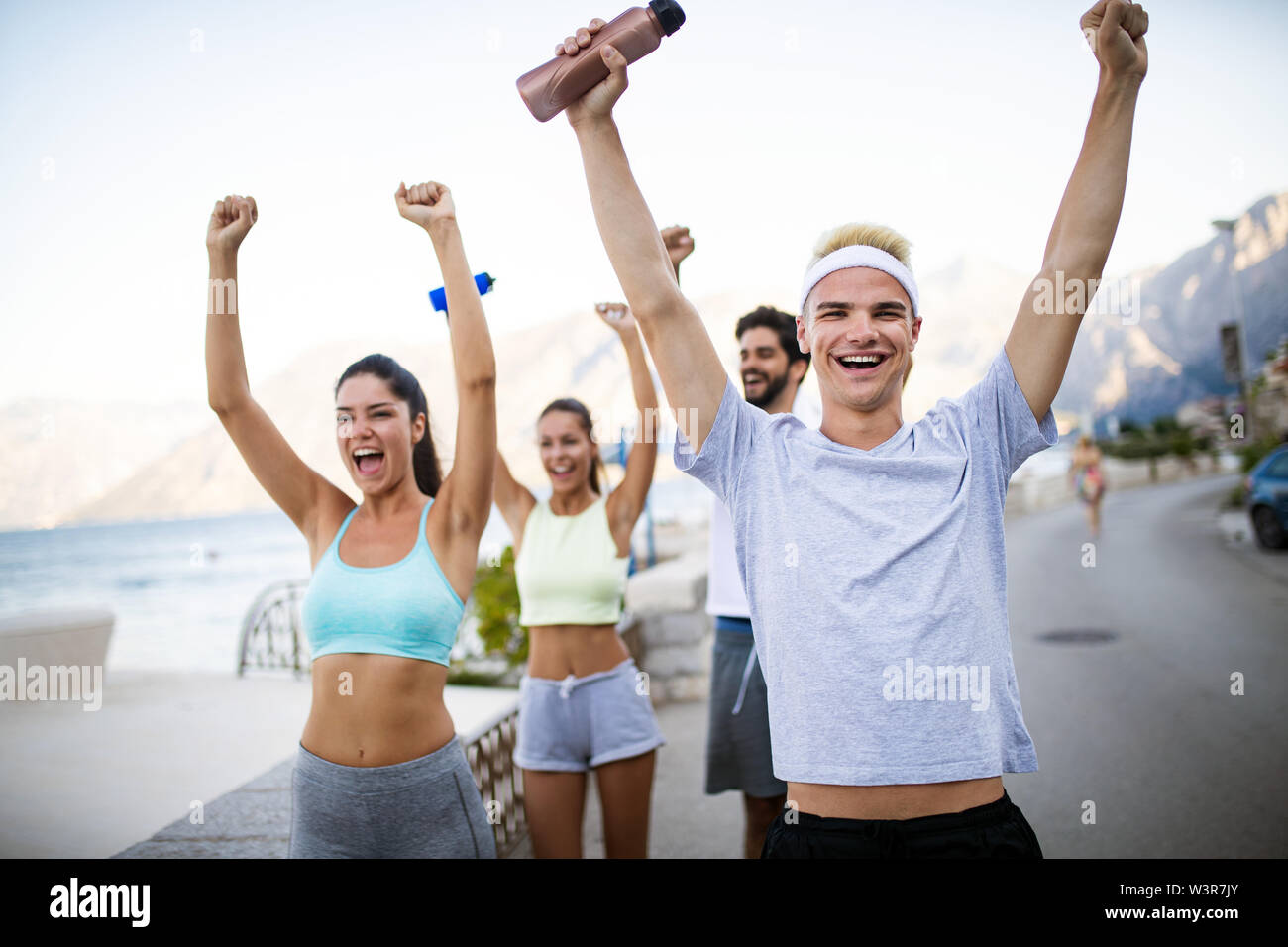 Outdoor portrait of group of friends running and jogging in nature ...