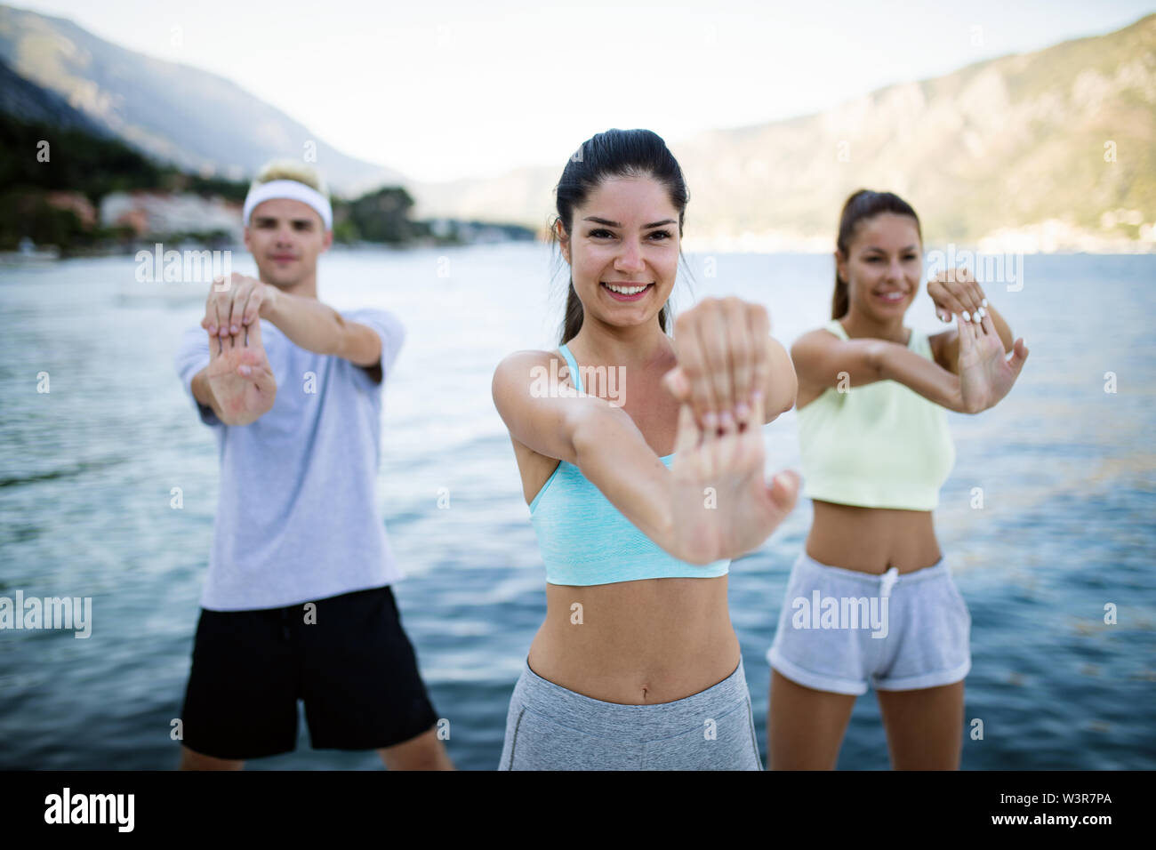Group of happy people exercising outdoor. Sport, fitness, friendship ...