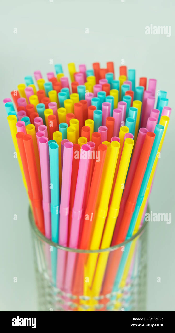Multi colored plastic drinking straws held together against a neutral ...