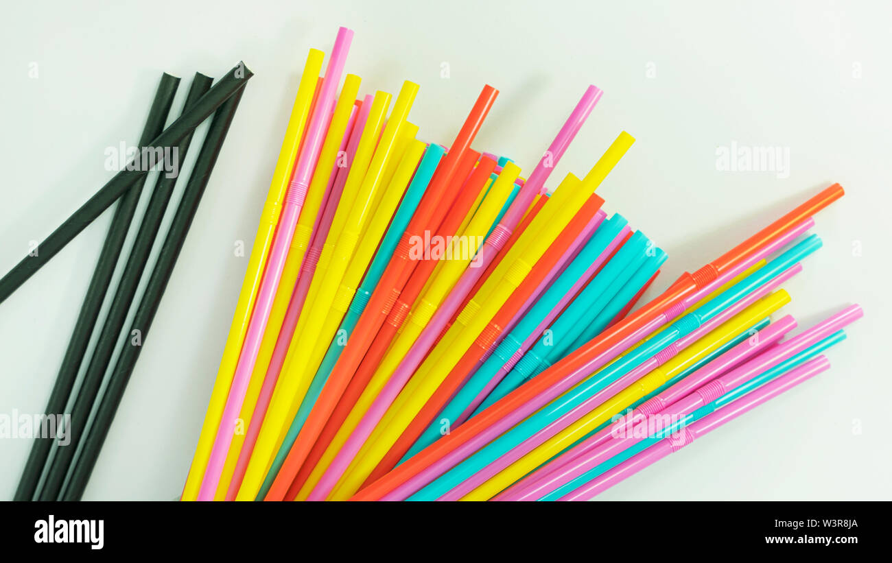 Multi colored plastic drinking straws and a few black paper drinking ...