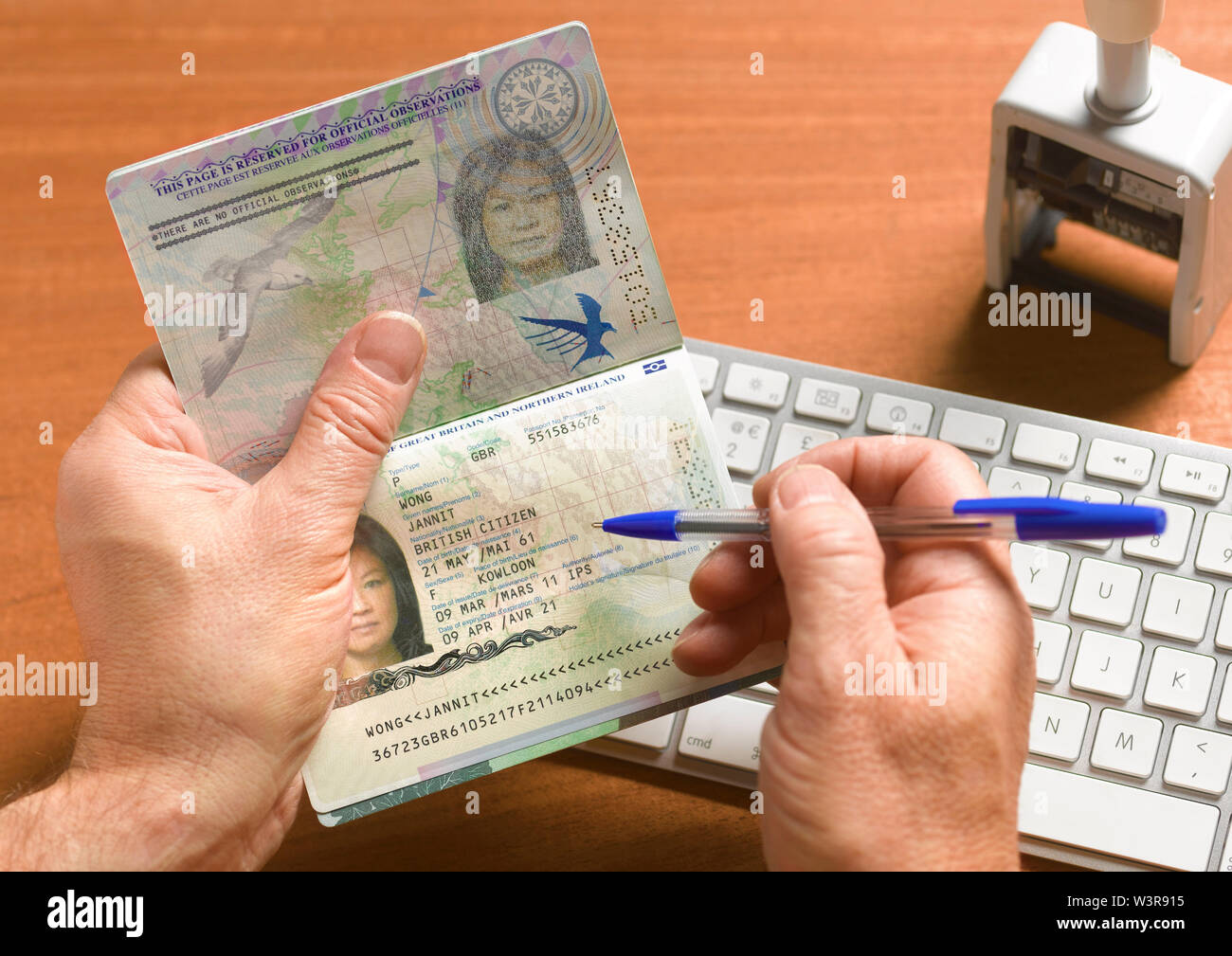 Border official checking woman traveller's UK passport Stock Photo - Alamy