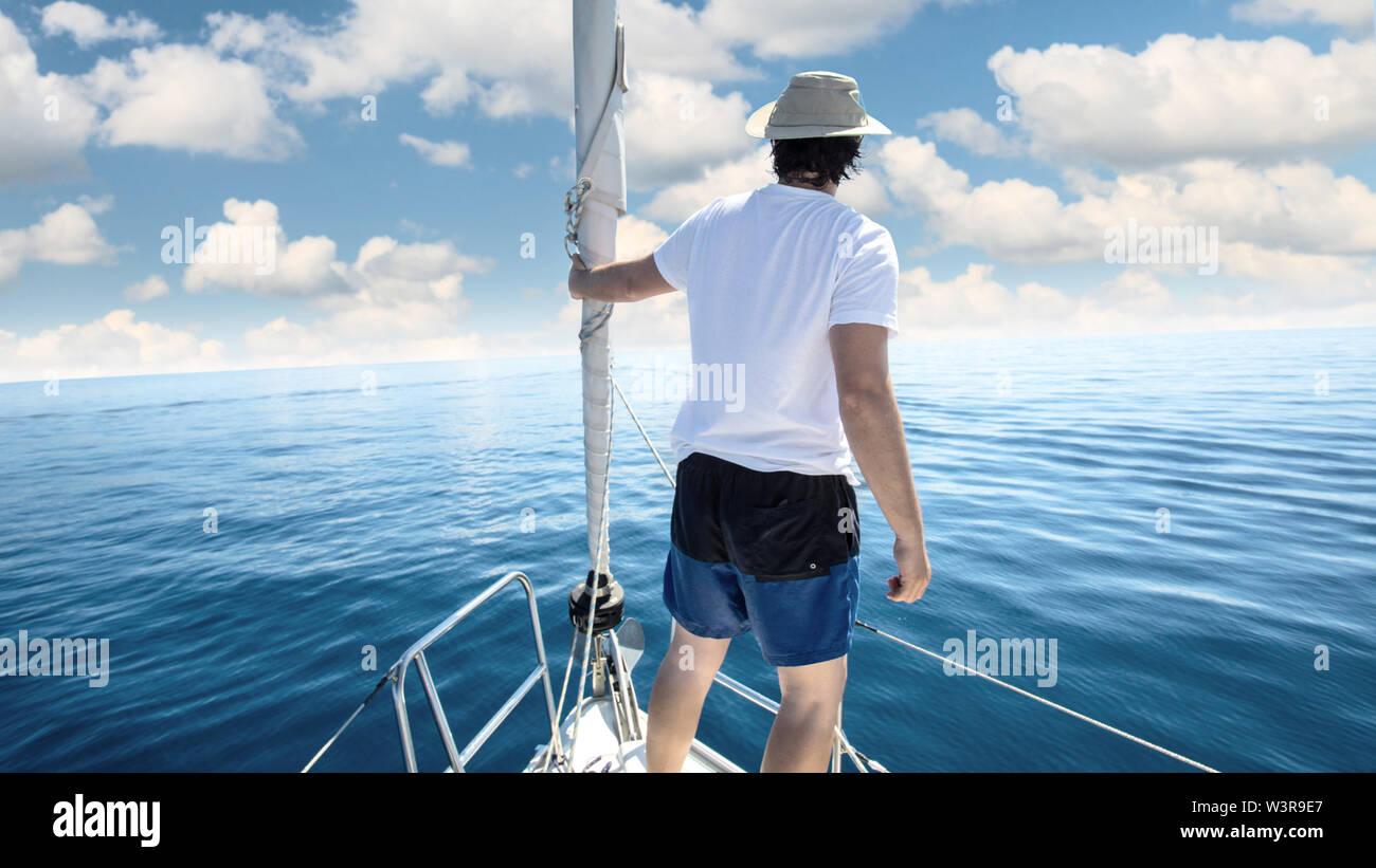 Man standing at the bow of a ship. Yachting, vacation and freedom ...