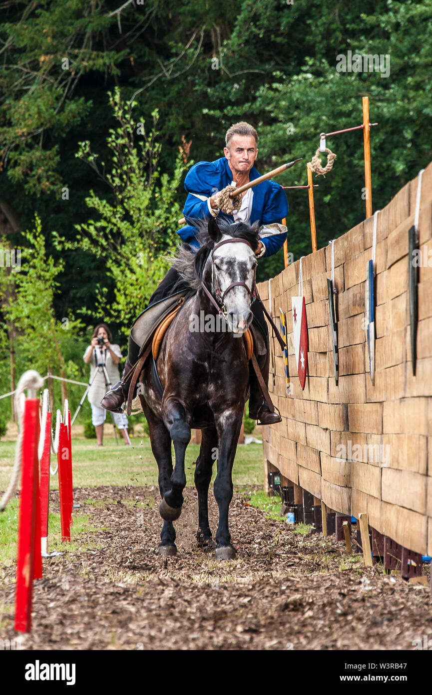 A contestant rides a horse to capture a ring. Skill at Arms ring game ...