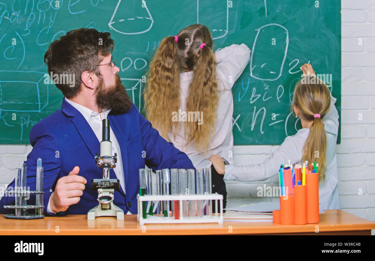 At the lesson. Male teacher giving private lesson to little children ...