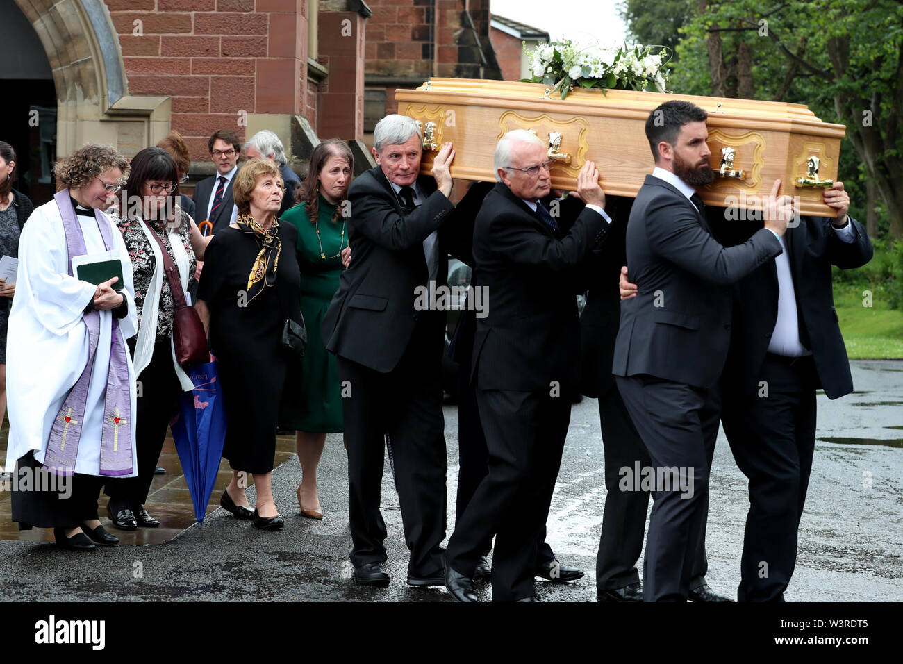 The coffin of Sir Anthony Hart is carried by his son David Hart (front ...