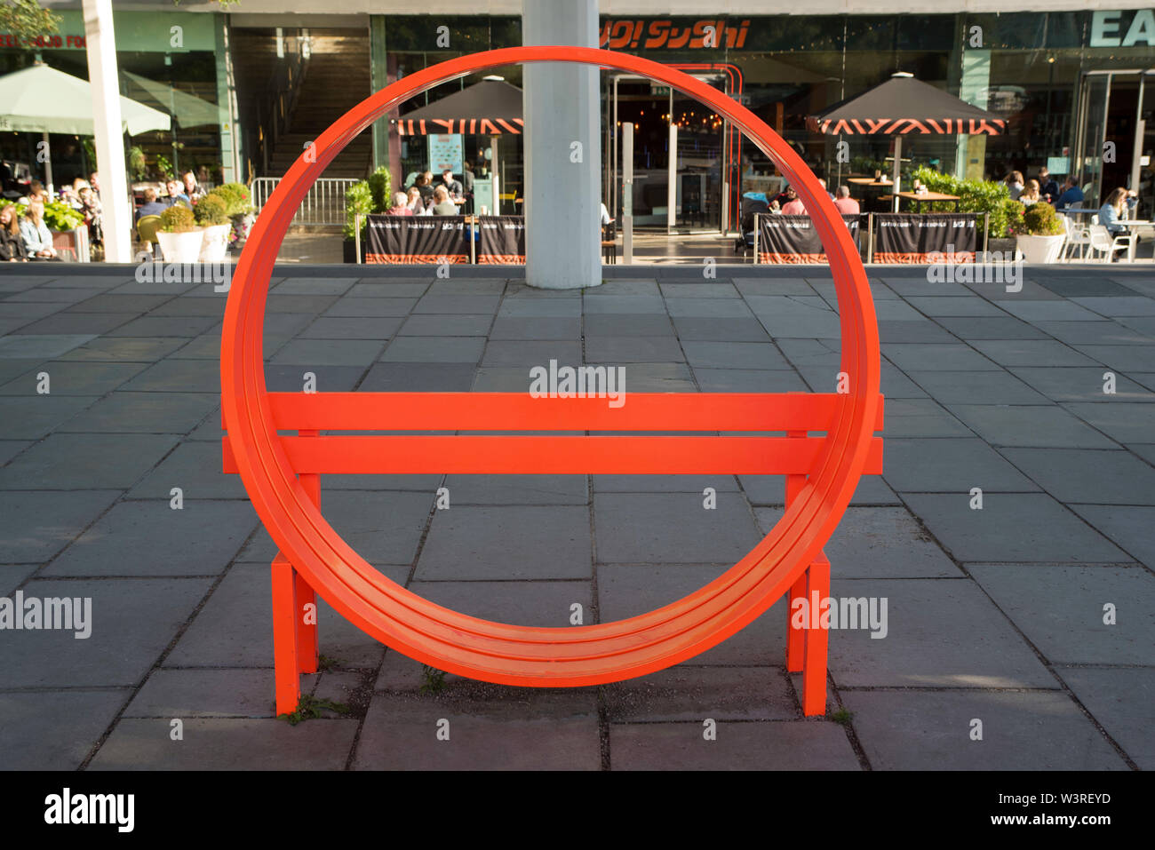 A public bench with a difference. Bright, fluorescent orange circular ...