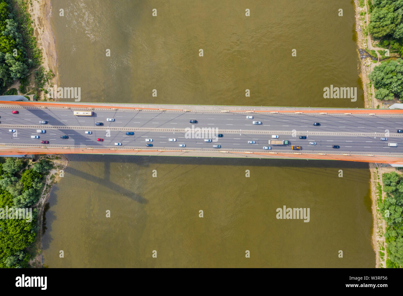 City car moving at highway bridge on background smooth river surface ...