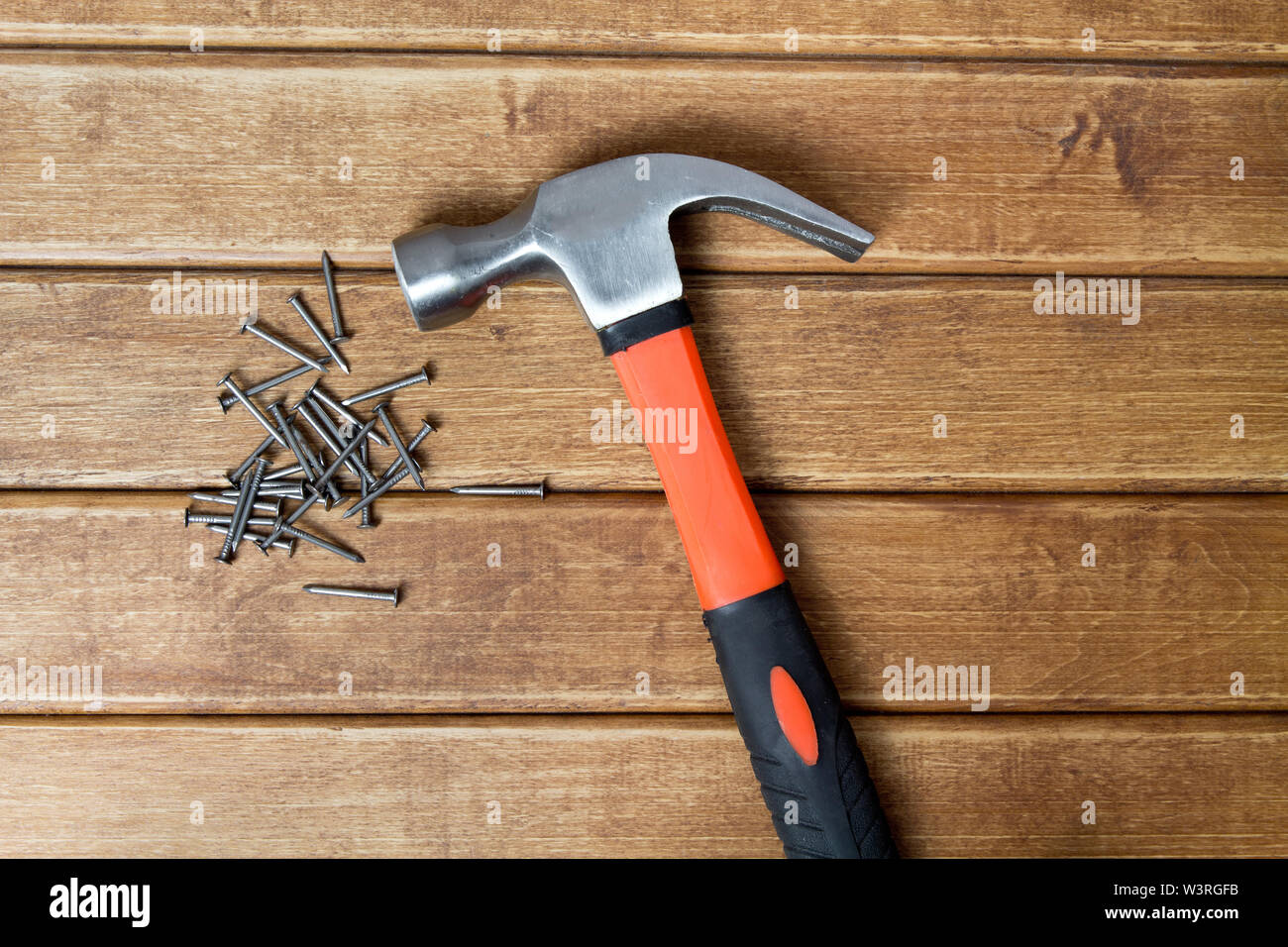 Hammer and nails scattered on wooden background. Joinery concept Stock ...