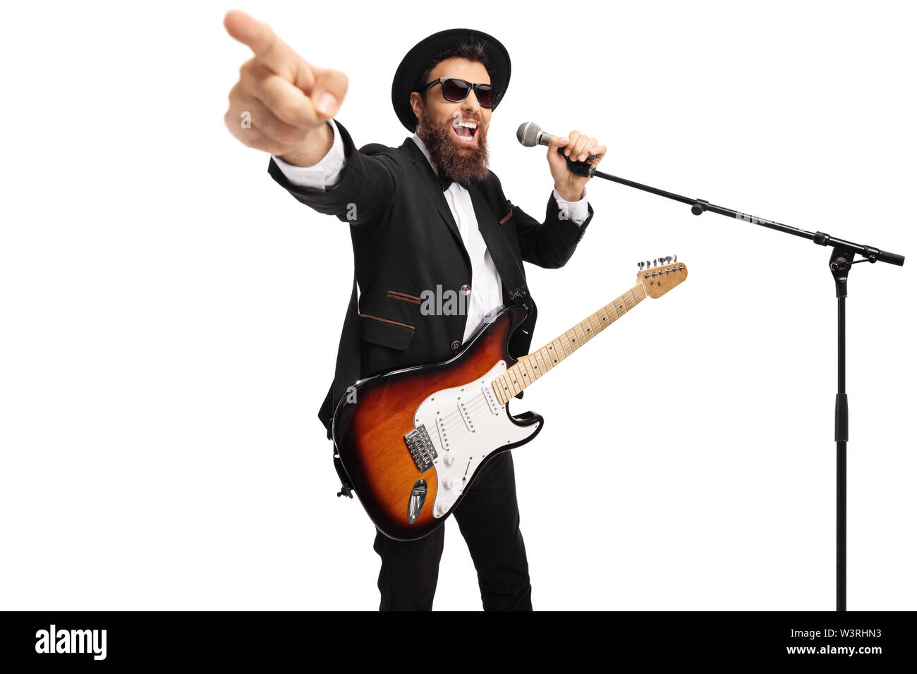 Man with an electric guitar singing on a microphone and pointing ...