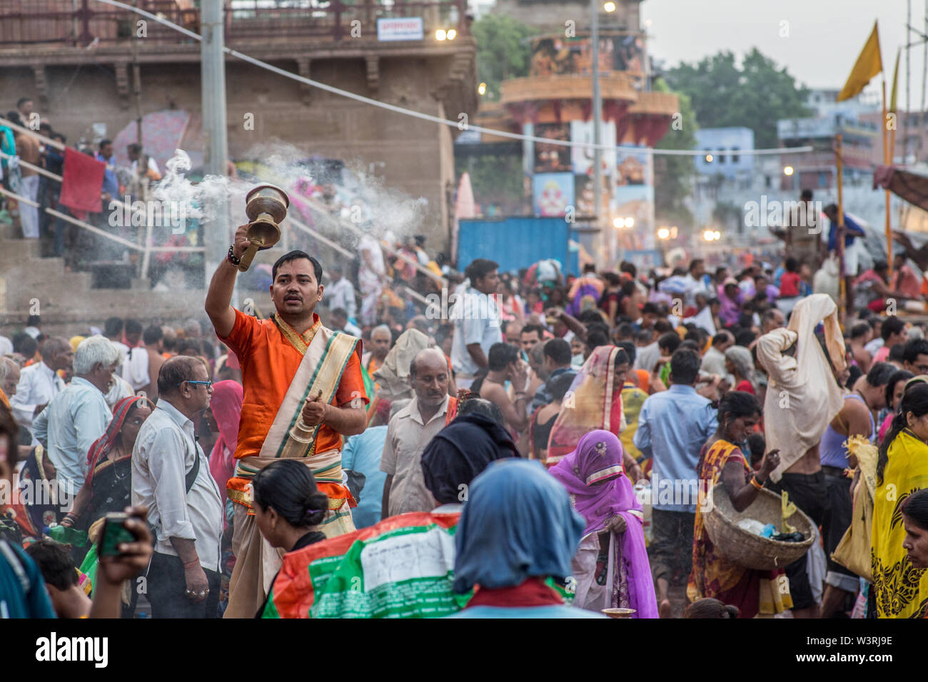 A man preforming a religious morning ceremony in the crowd in Varanasi ...
