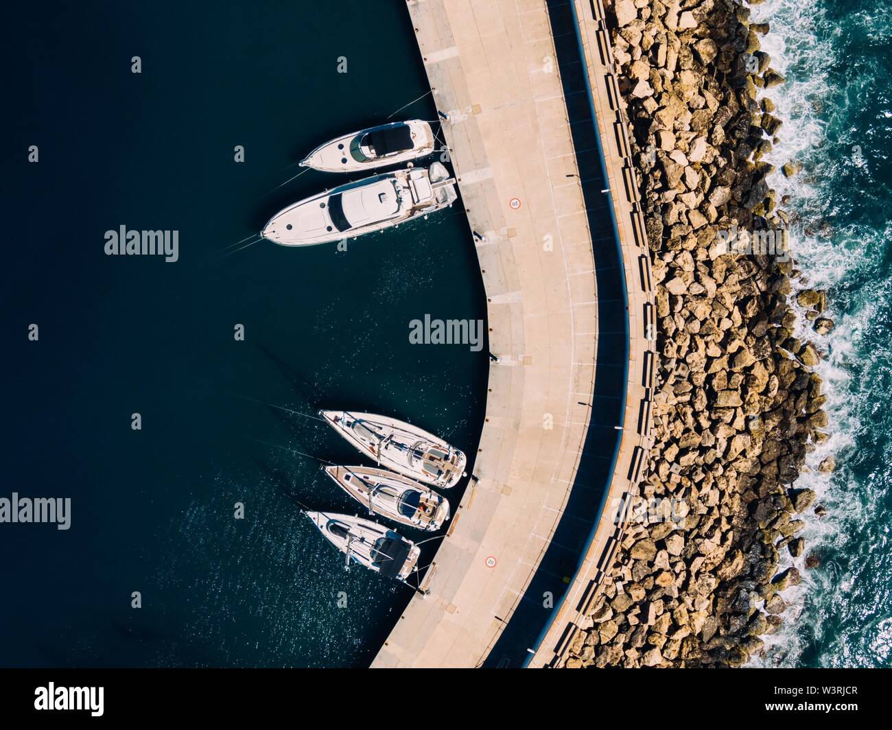 Aerial overhead shot of white sailboats docked on the coast of the ...