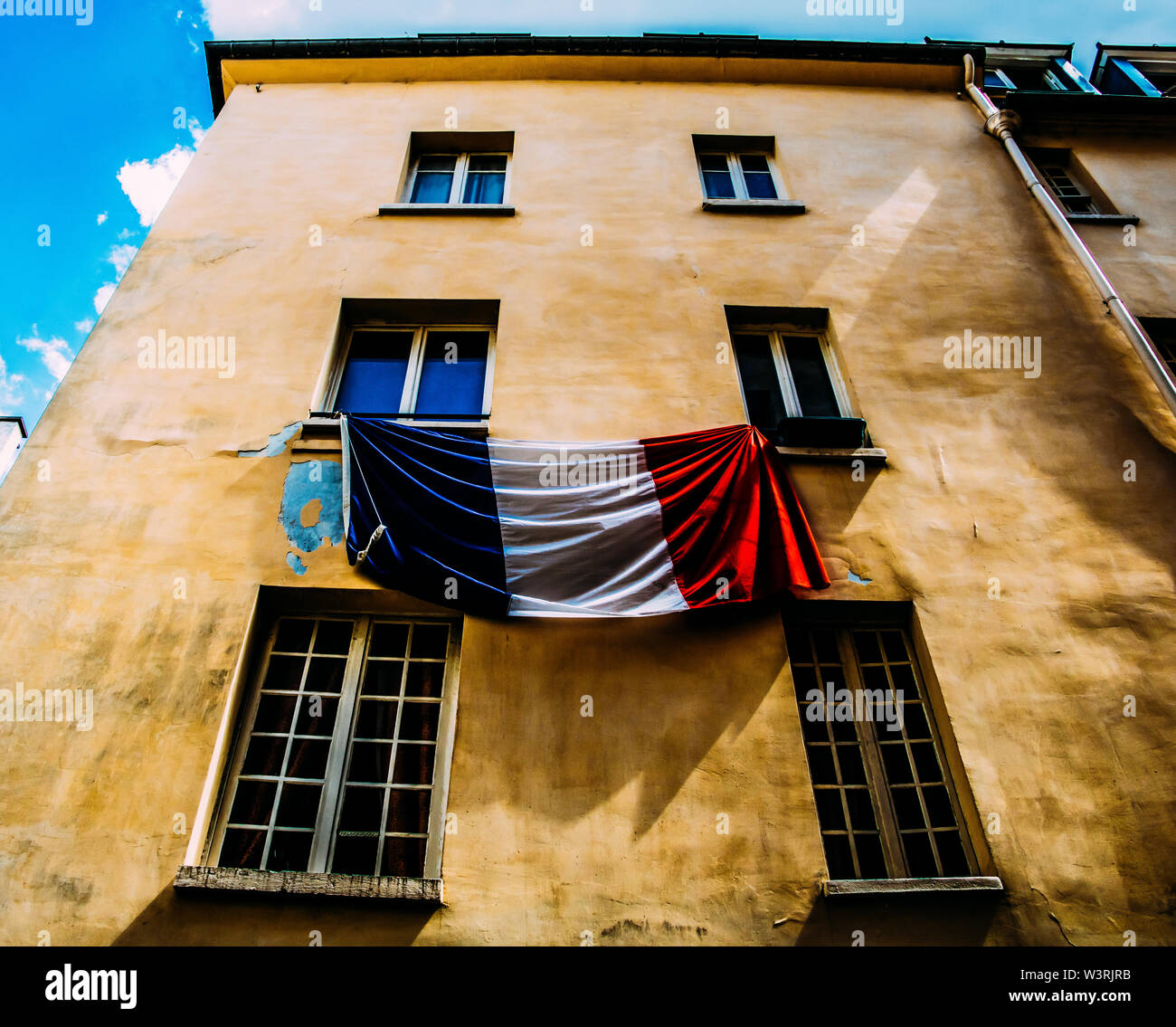 French flag on facade of a building in Paris Stock Photo - Alamy