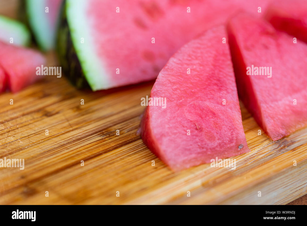 A watermelon cut on a wooden board Stock Photo - Alamy