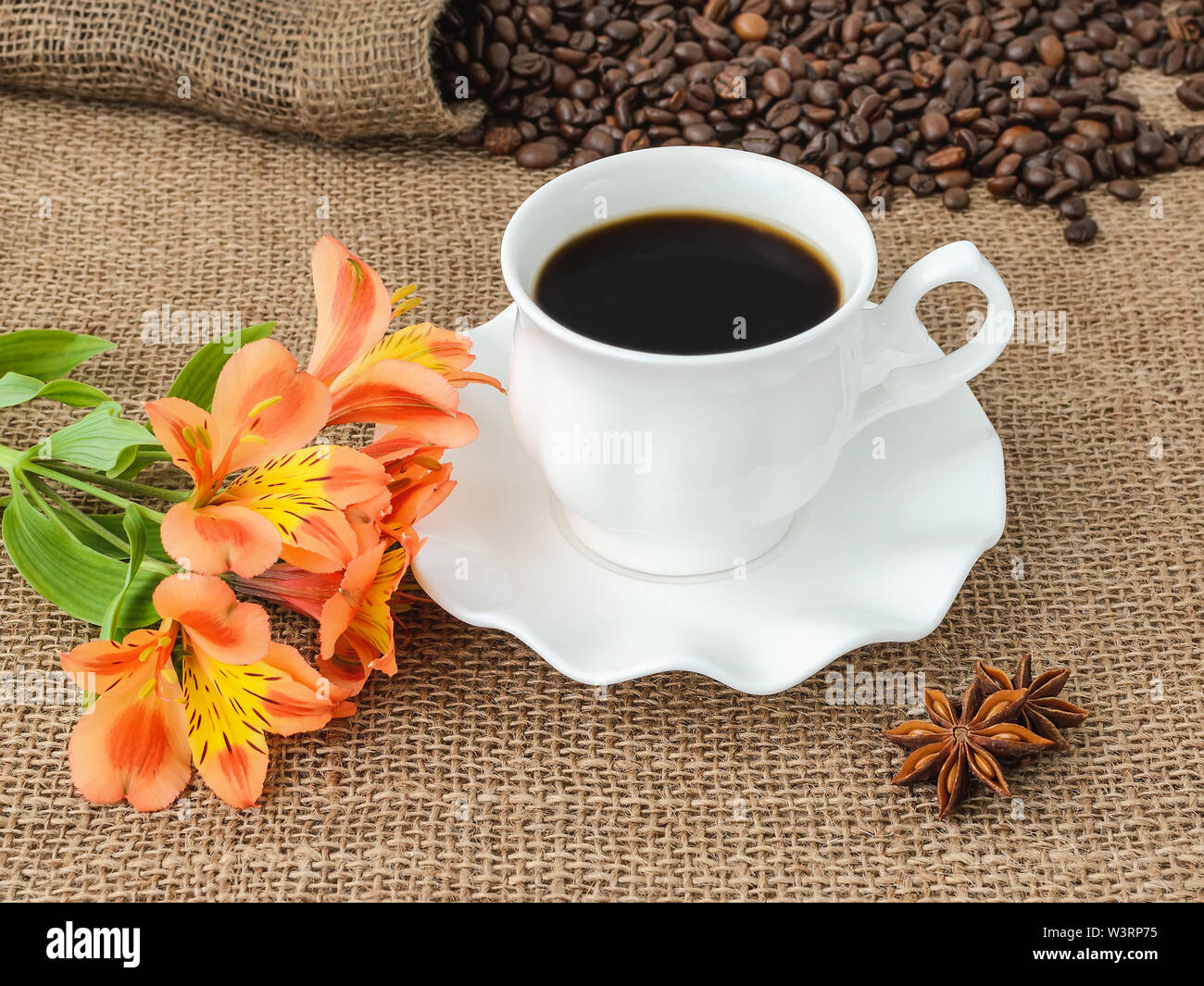 Orange peruvian lily flower, hot coffee in white elegant cup with ...