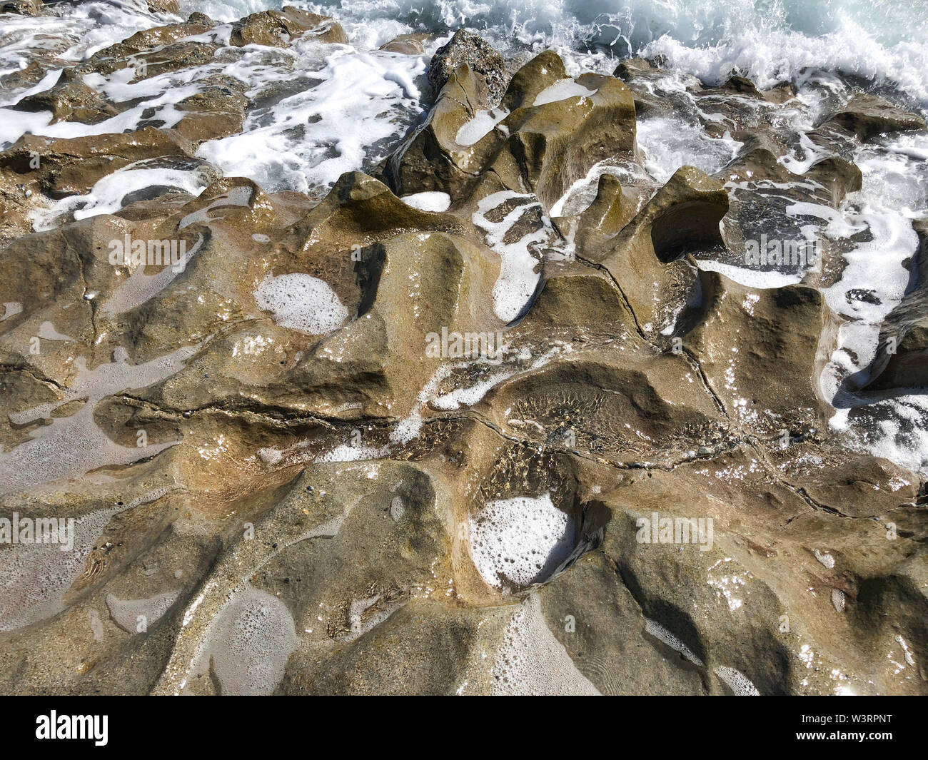 Stones by the sea of fancy shape and color. Foamy surf of the sea Stock ...