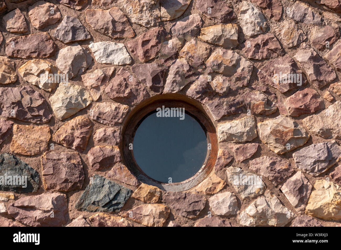 A close up view of a round glass window in the front stone building ...