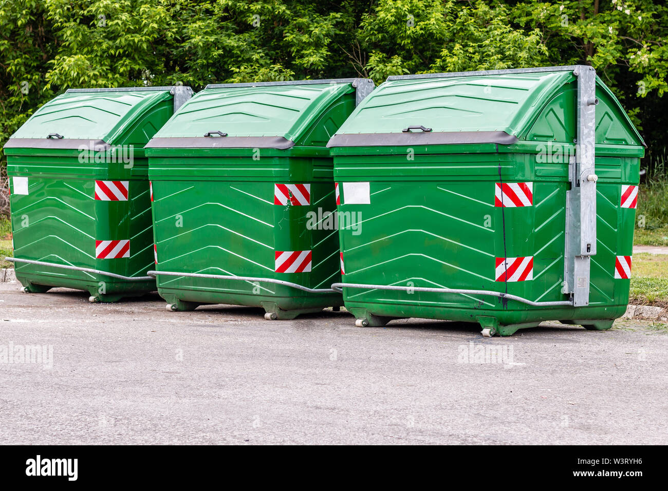 Three green recycle bins in row, outdoors. Environment and pollution ...