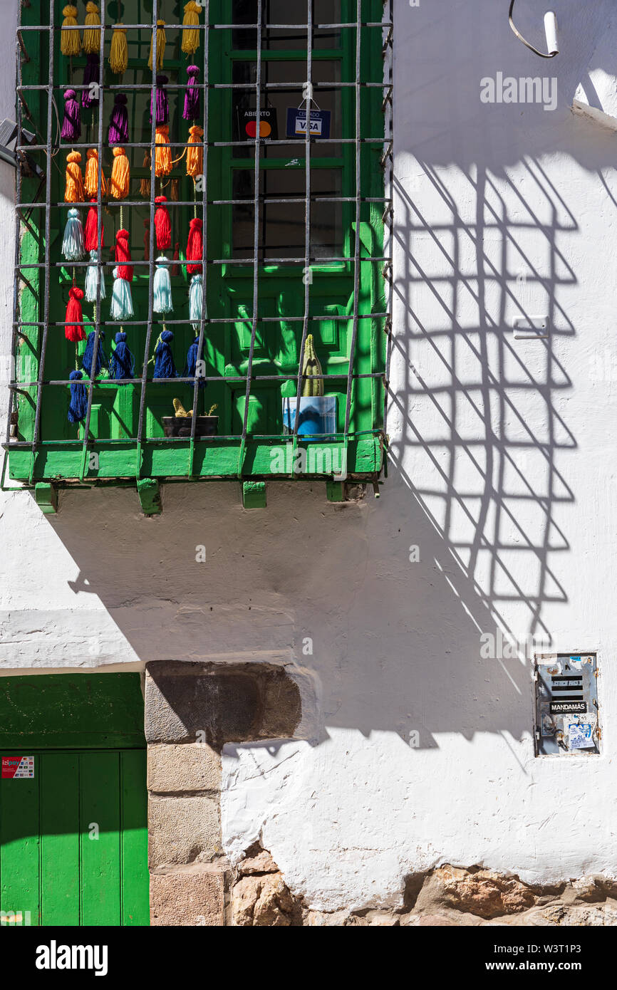 Barred window with knitted colourful toggles and shadows in Cusco, Peru ...