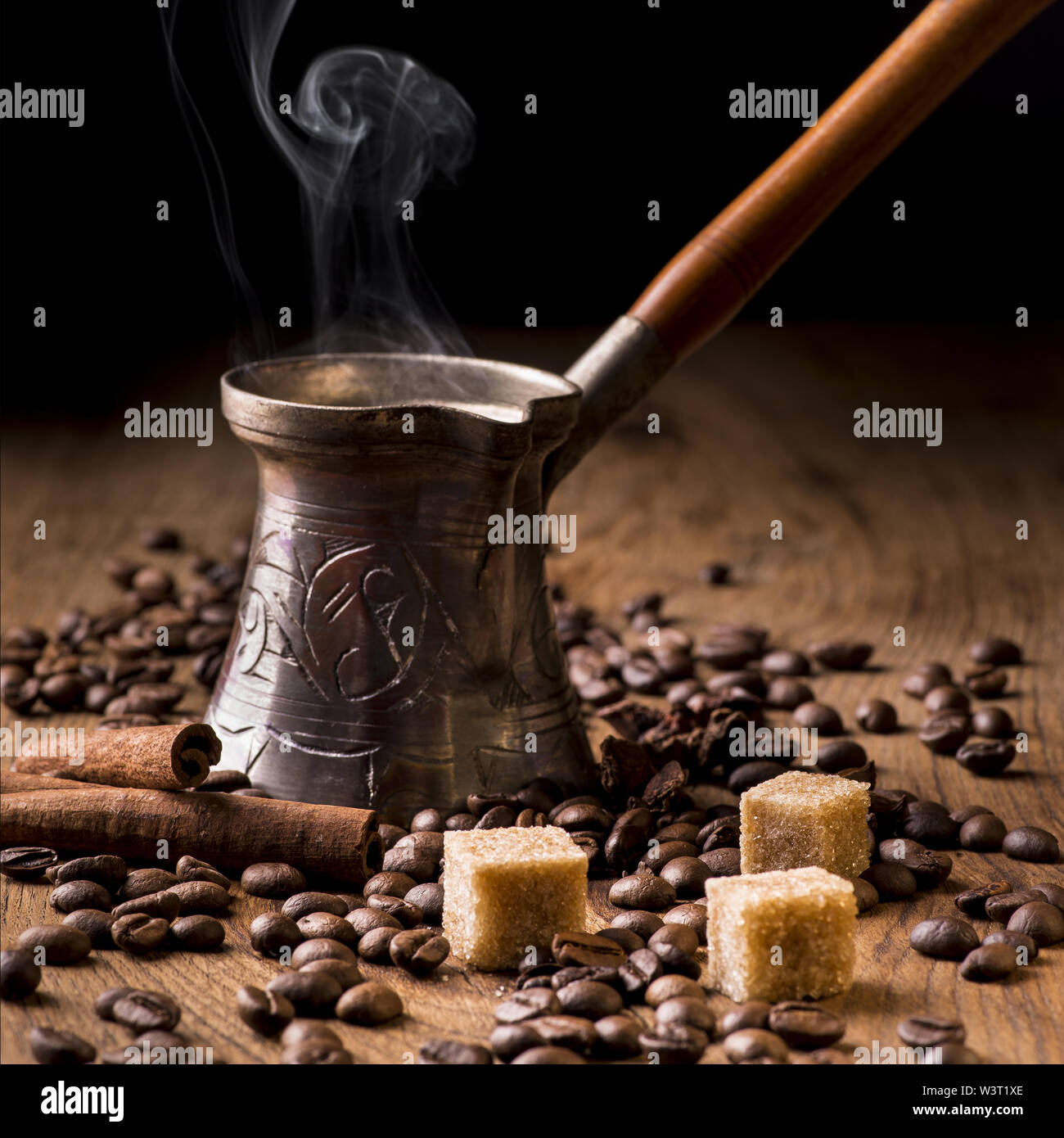 turkish coffee boiling in coffee pot and roasted coffee beans on wooden ...
