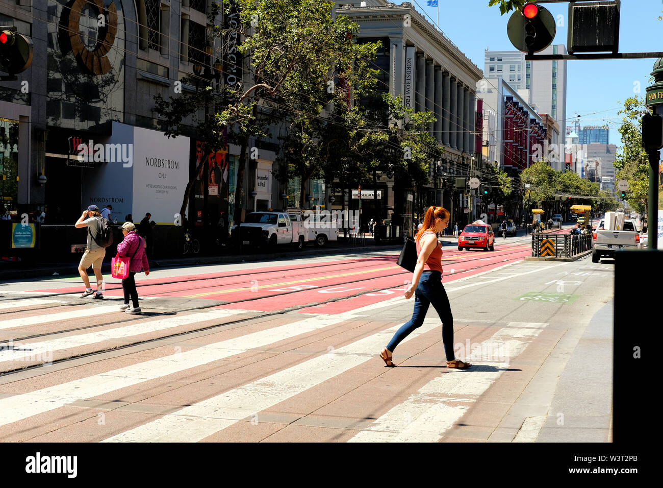 Pedestrians using a crosswalk to walk across Market Street in downtown ...