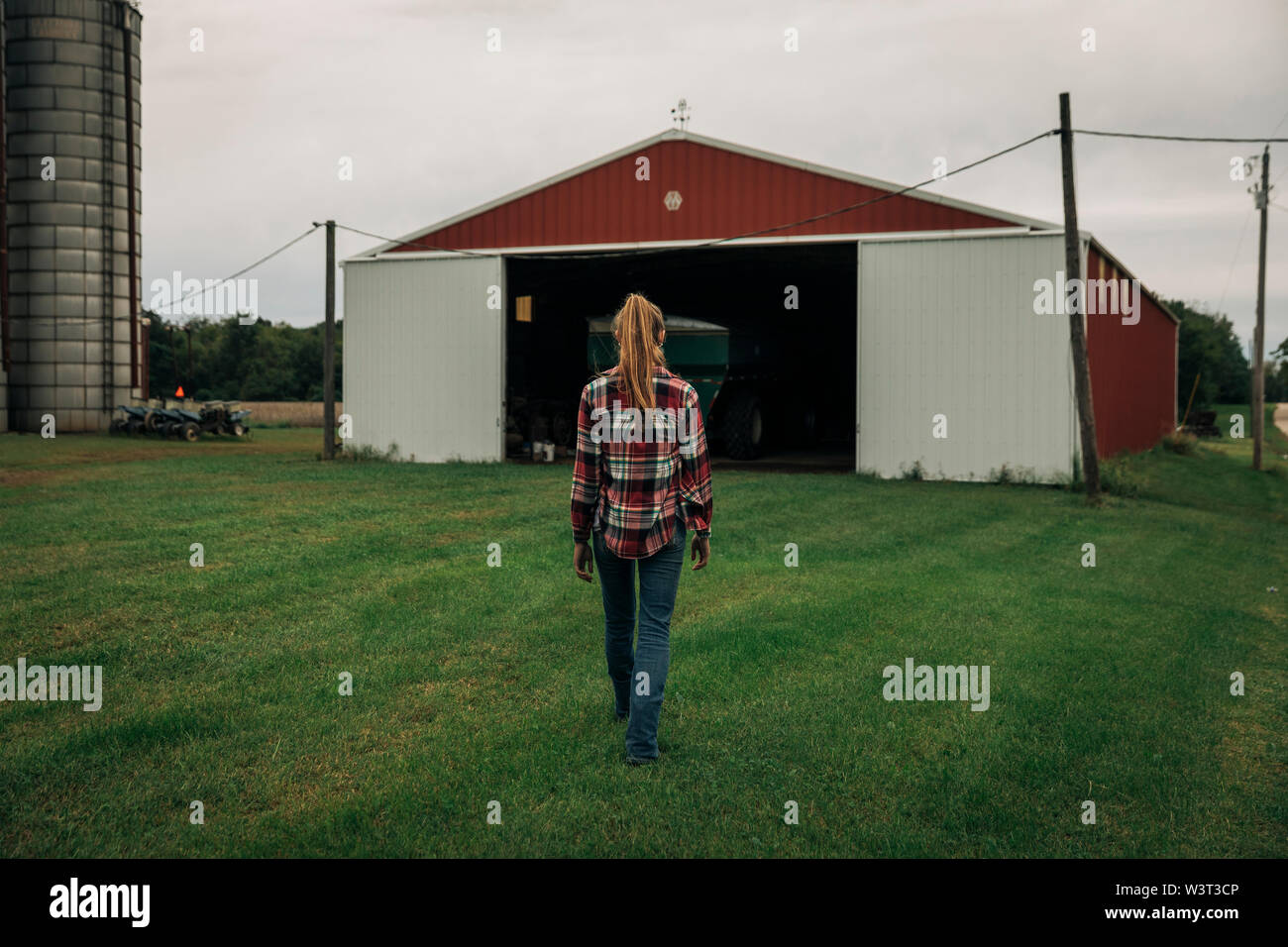 Female Farmer Walking To Red Barn Stock Photo - Alamy