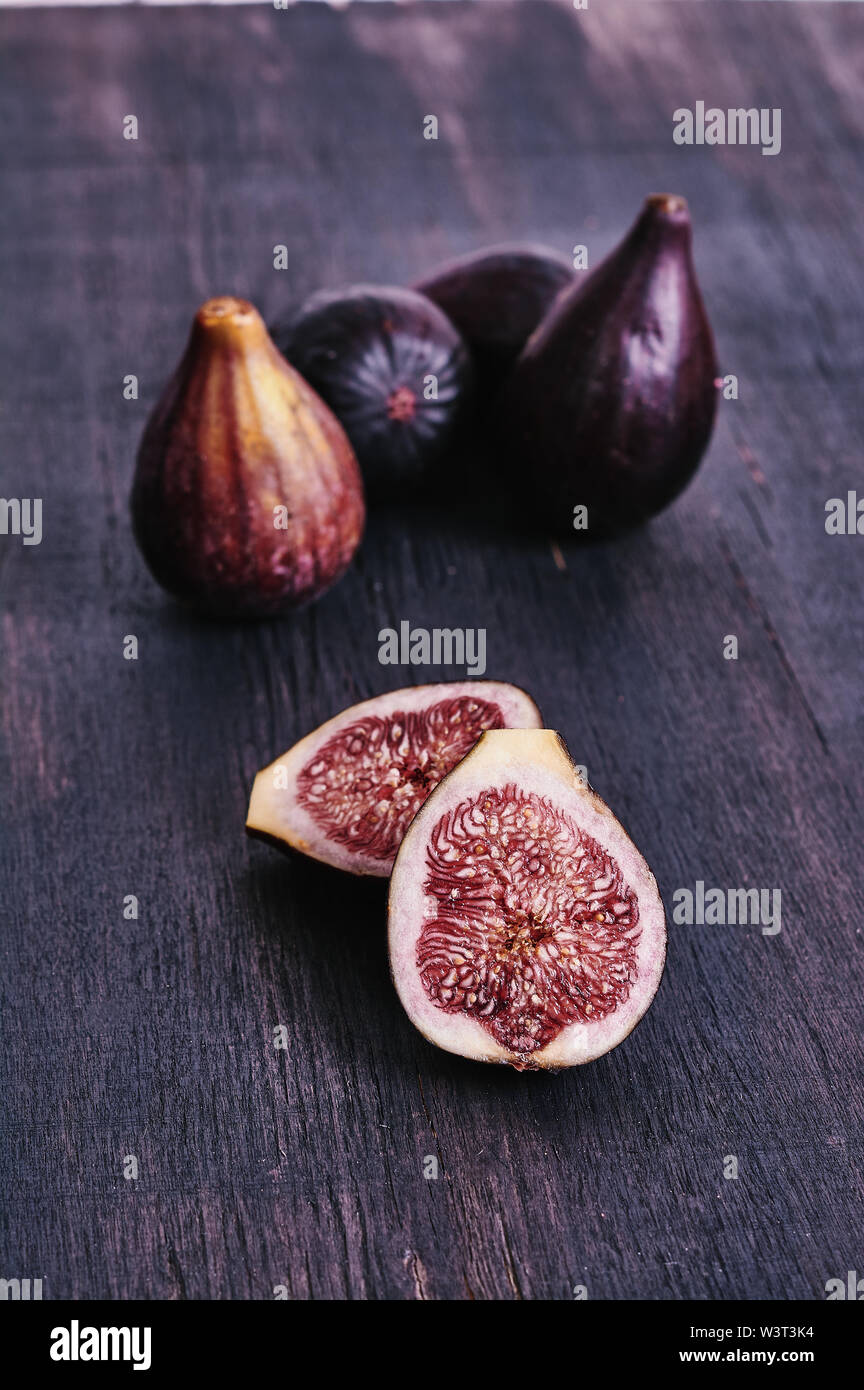 Figs isolated on dark wood background Stock Photo - Alamy