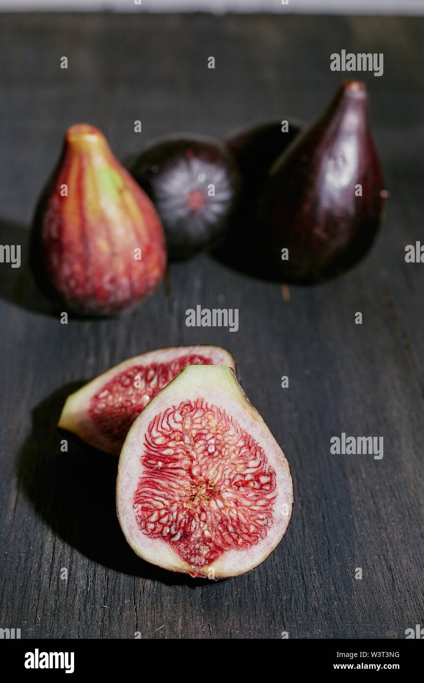 Figs isolated on dark wood background Stock Photo - Alamy