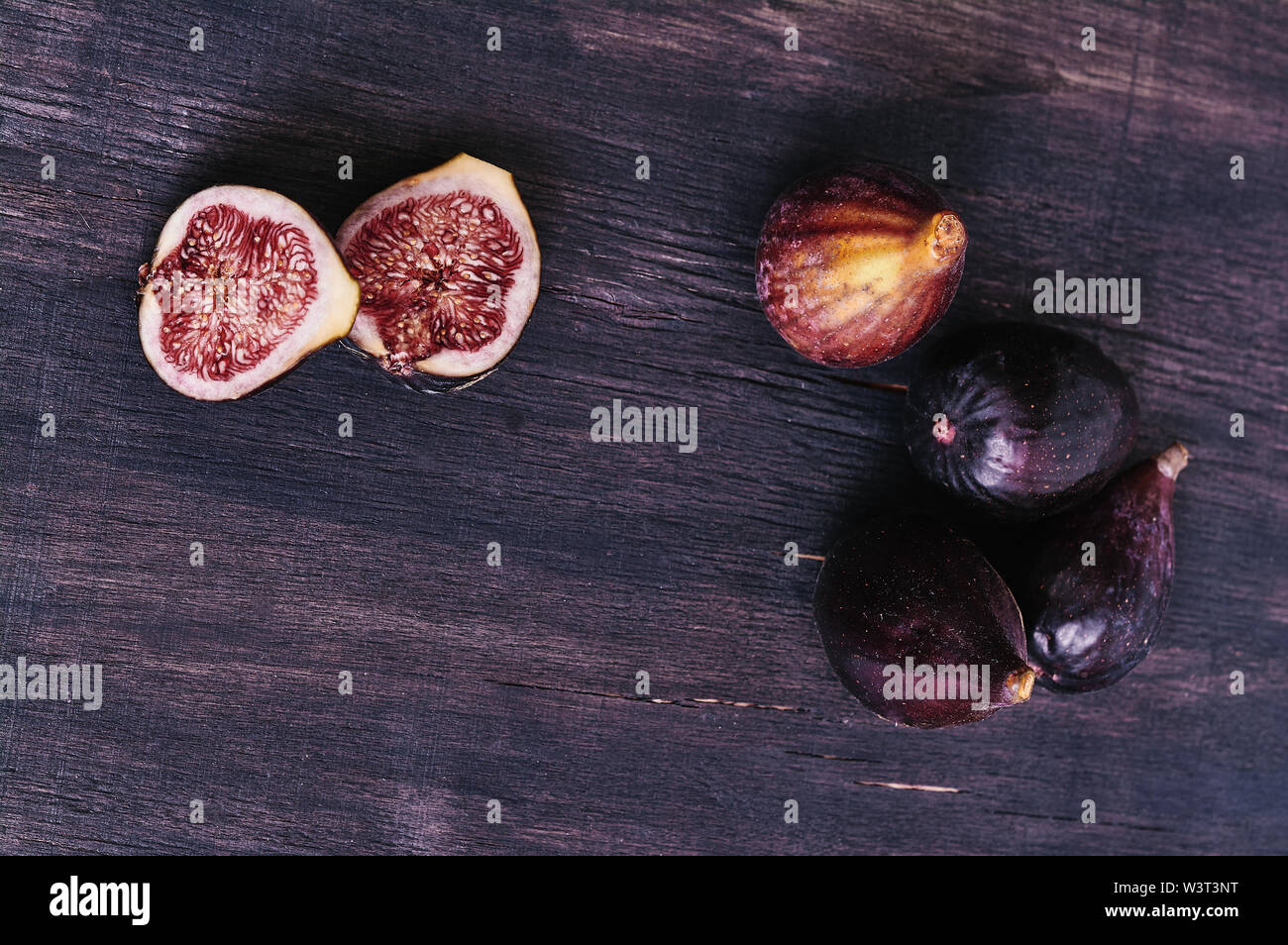 Figs isolated on dark wood background Stock Photo - Alamy
