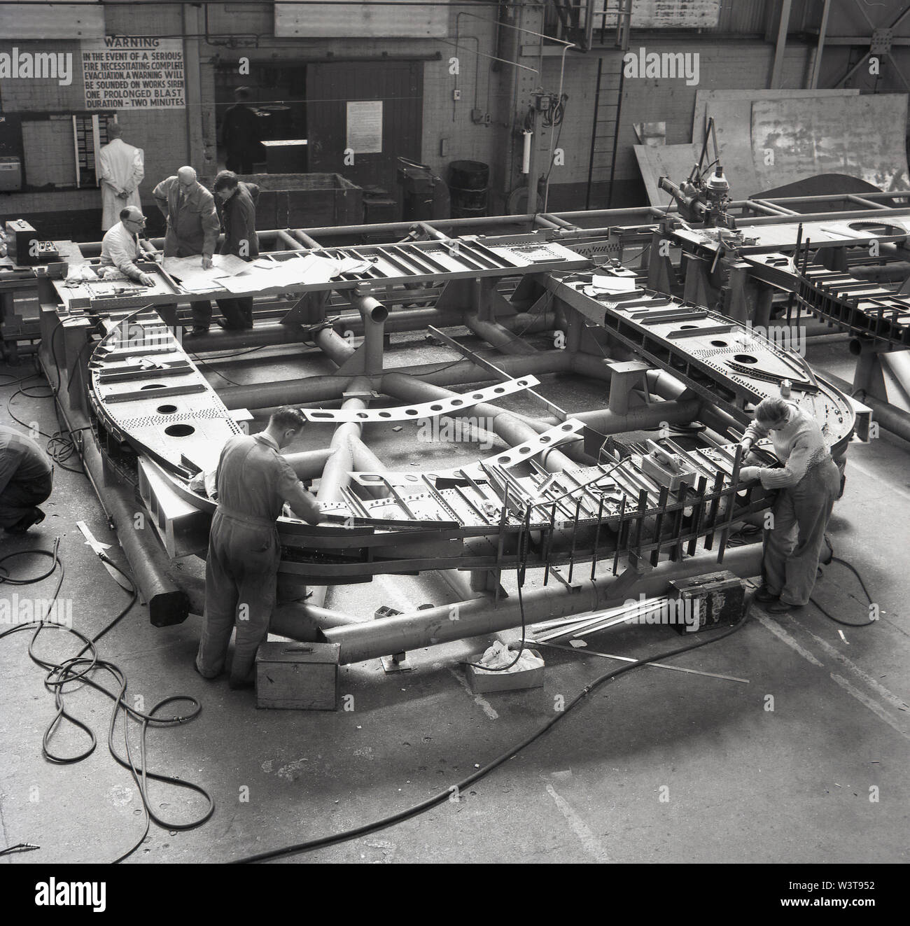 Late 1950s, historical, engineering workers inside an aviation factory ...
