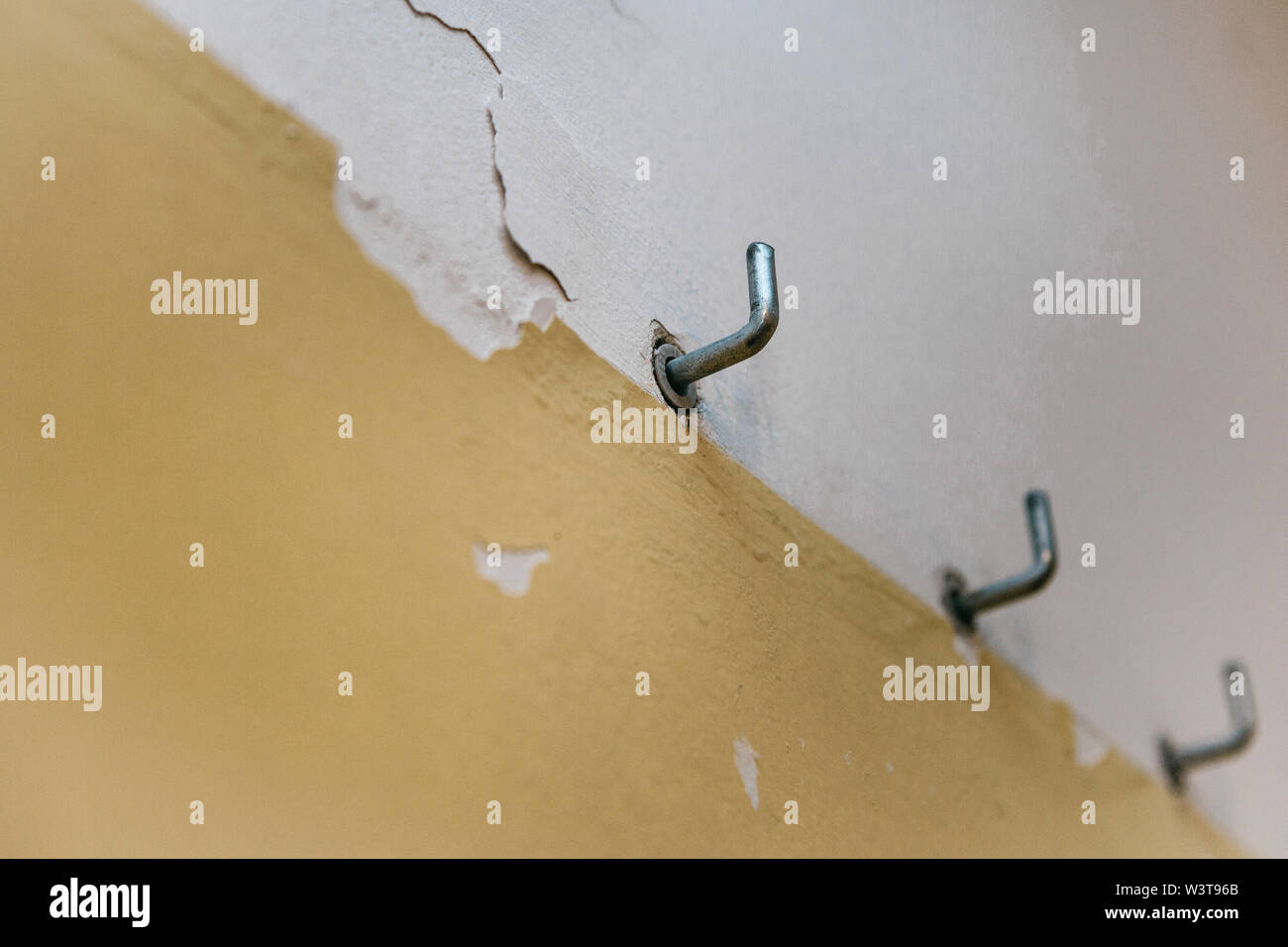 Old wall with hooks and whipped whitewash Stock Photo - Alamy