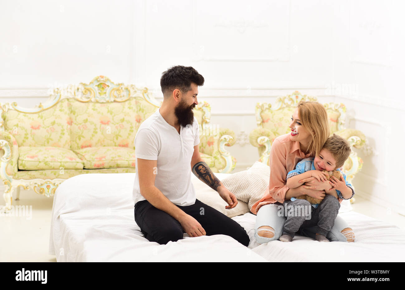 Young family spend time together on bed, luxury interior background ...