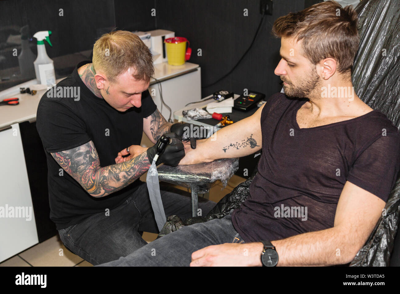Professional tattooer doing picture on hand of man Stock Photo - Alamy