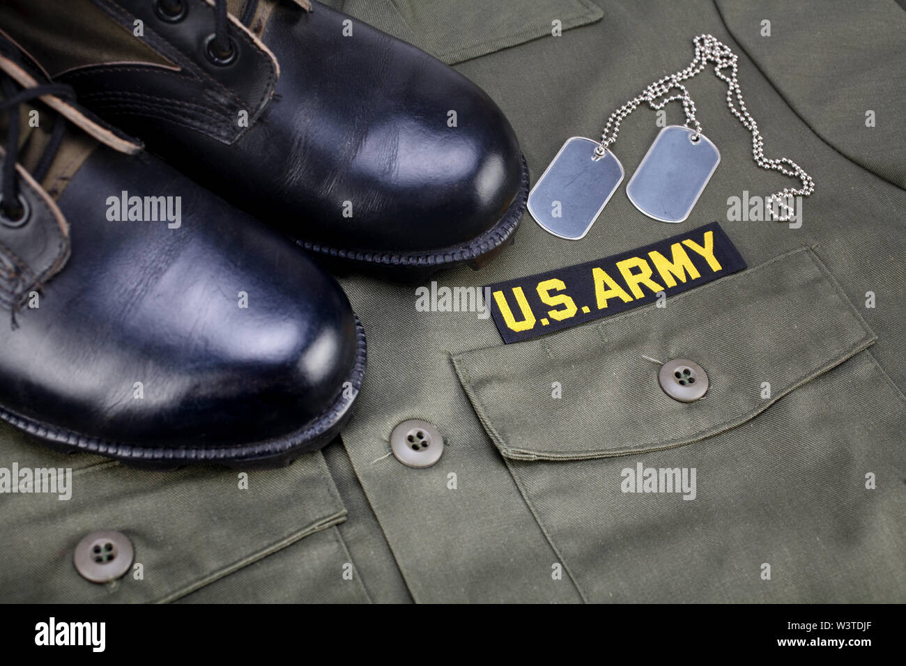 U.S. Army Branch Tape with dog tags and boots on olive green uniform ...