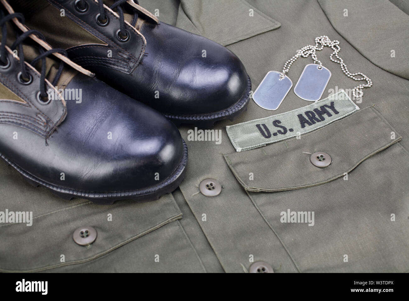 U.S. Army Branch Tape with dog tags and boots on olive green uniform ...