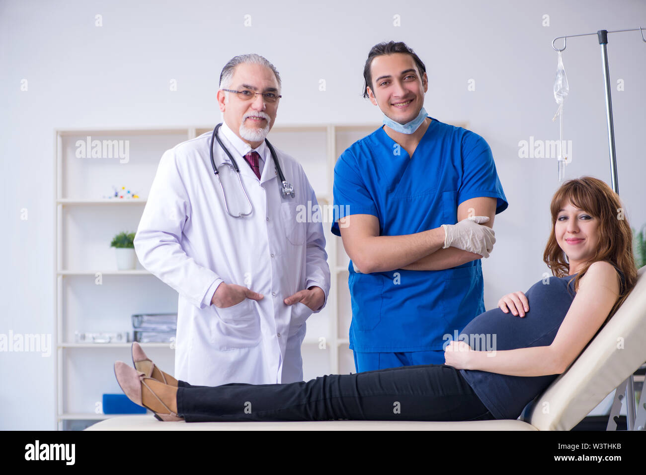 The two doctors examining young woman Stock Photo - Alamy