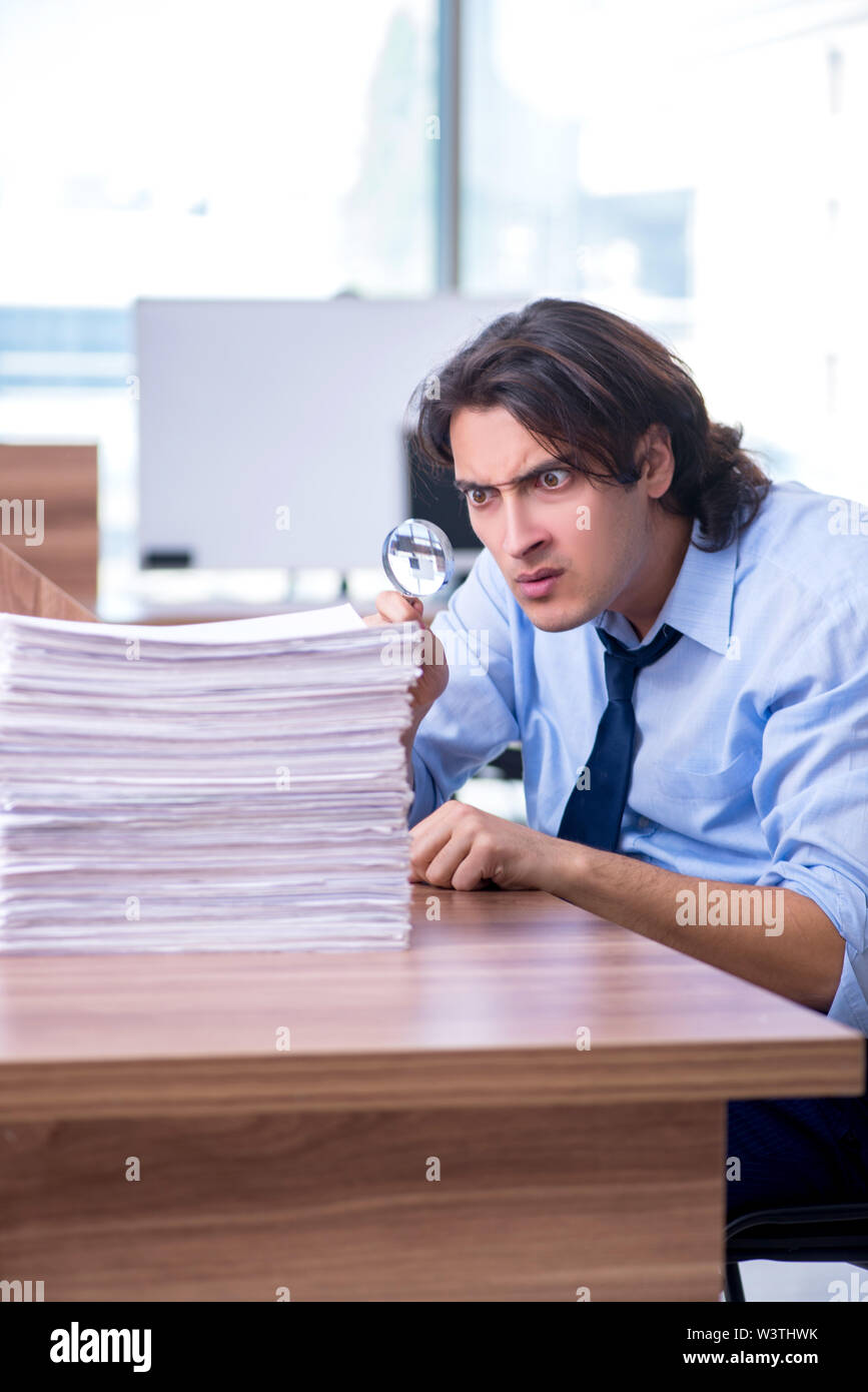 The young employee unhappy with excessive work Stock Photo - Alamy