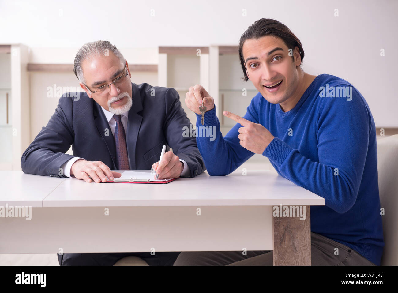 The male real estate agent and male client in the apartment Stock Photo ...