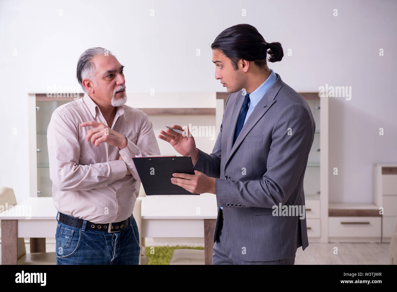 The male real estate agent and male client in the apartment Stock Photo ...