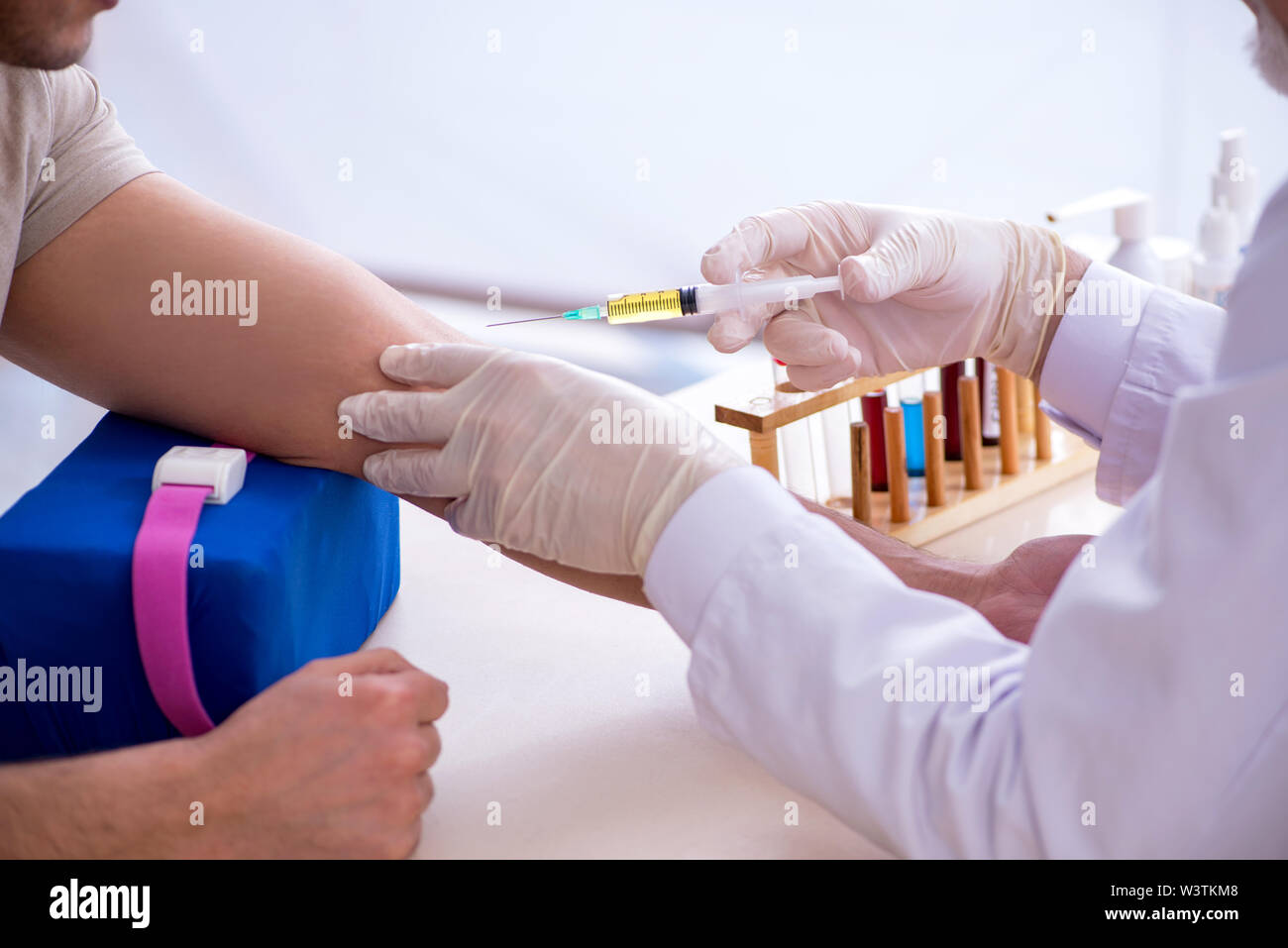 The young handsome man during blood test sampling procedure Stock Photo ...