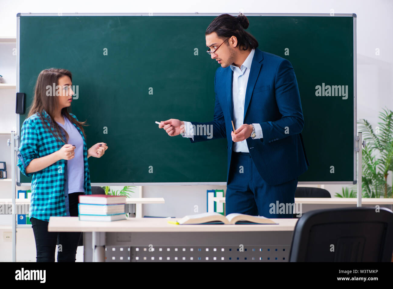 The young handsome teacher and female student in the classroom Stock ...