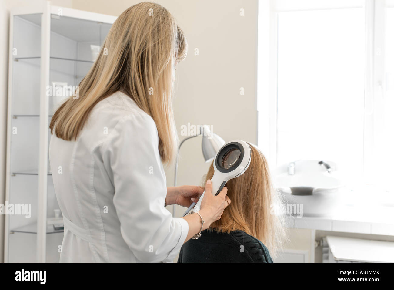 The doctor trichologist dermatologist examines the scalp and the ...