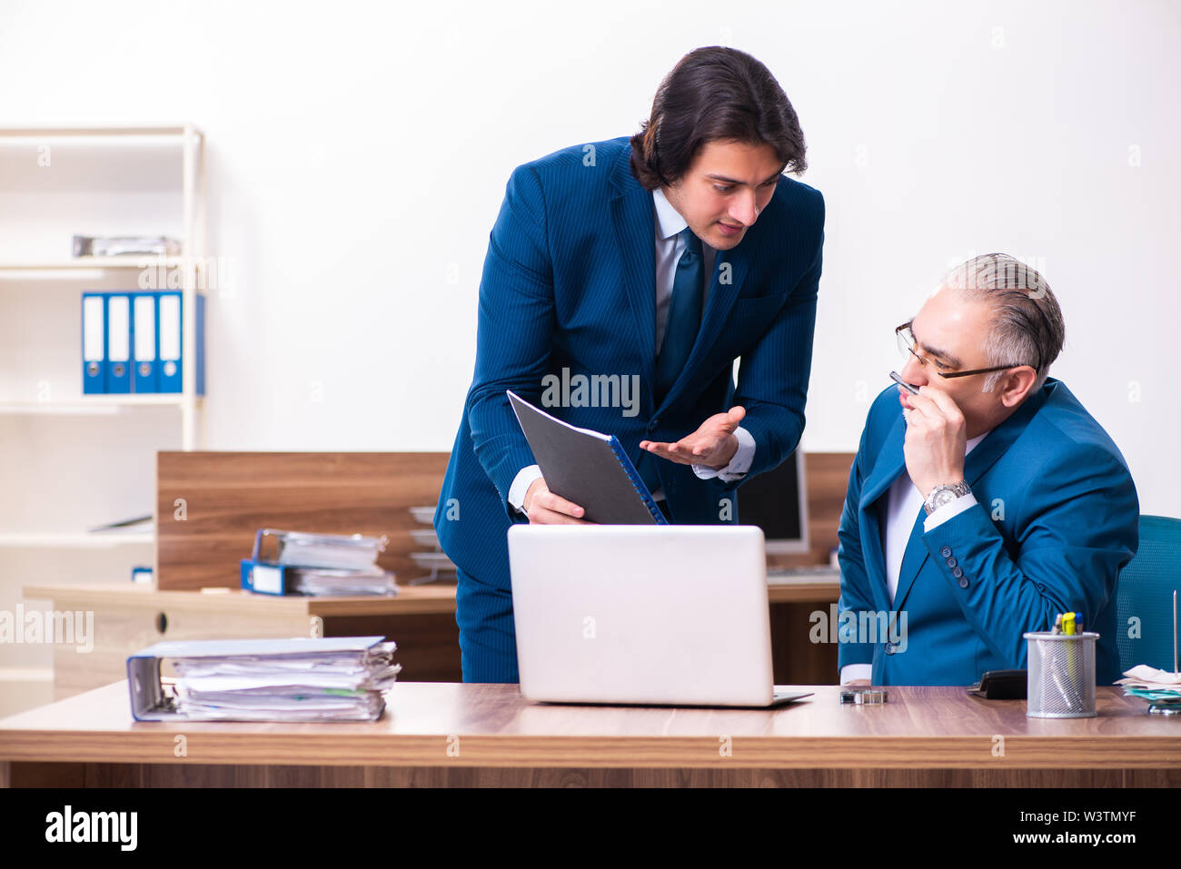 The young and old employees working together in the office Stock Photo ...