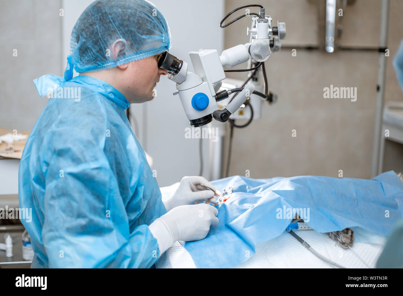 A professional ophthalmologist performs eye surgery with a microscope ...