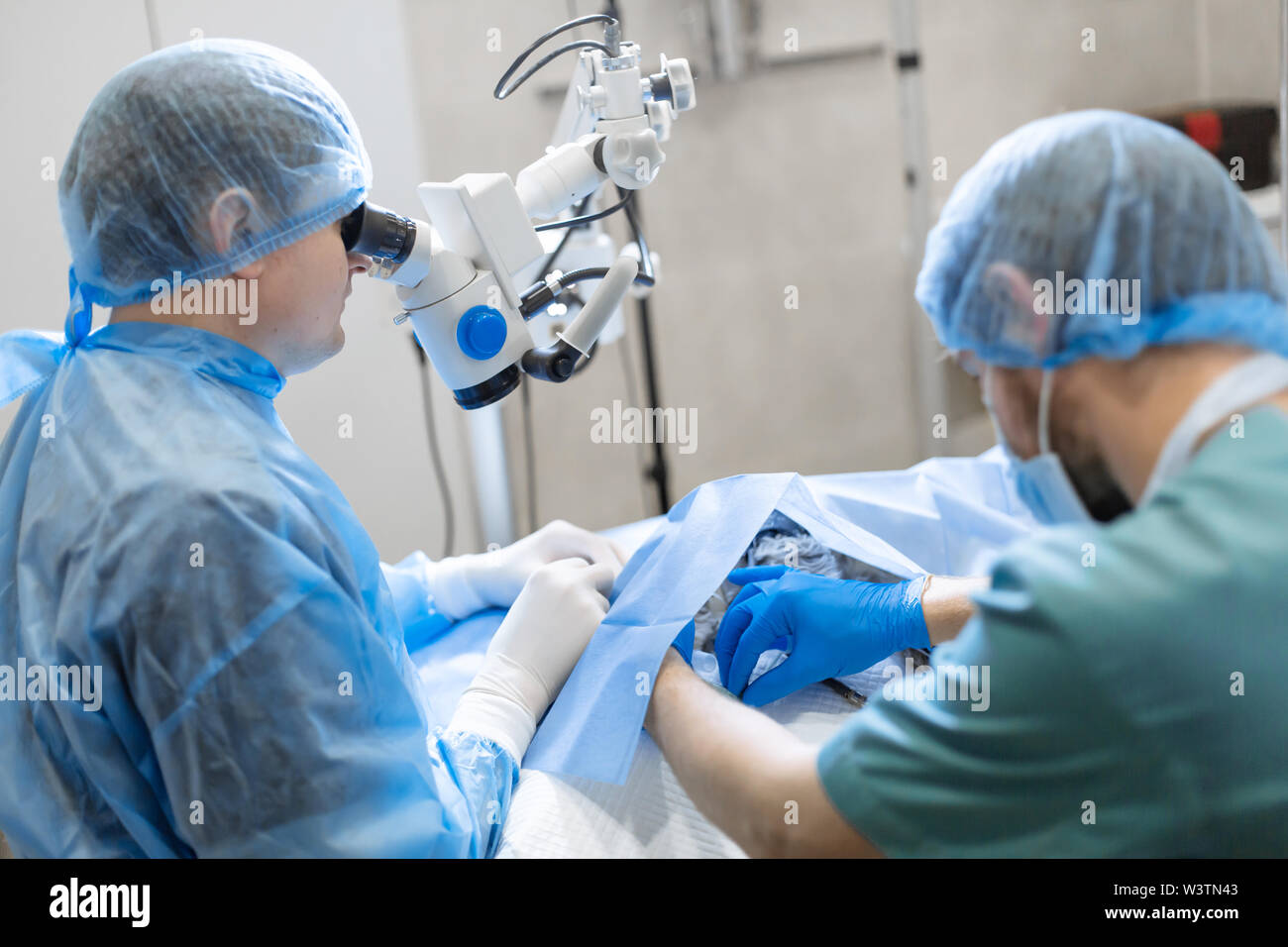 A professional ophthalmologist performs eye surgery with a microscope ...