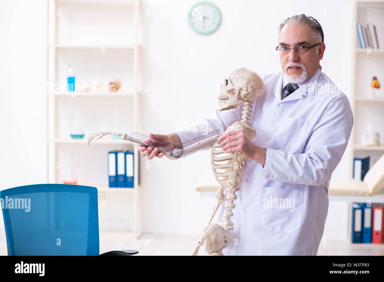 The aged male doctor with skeleton Stock Photo - Alamy