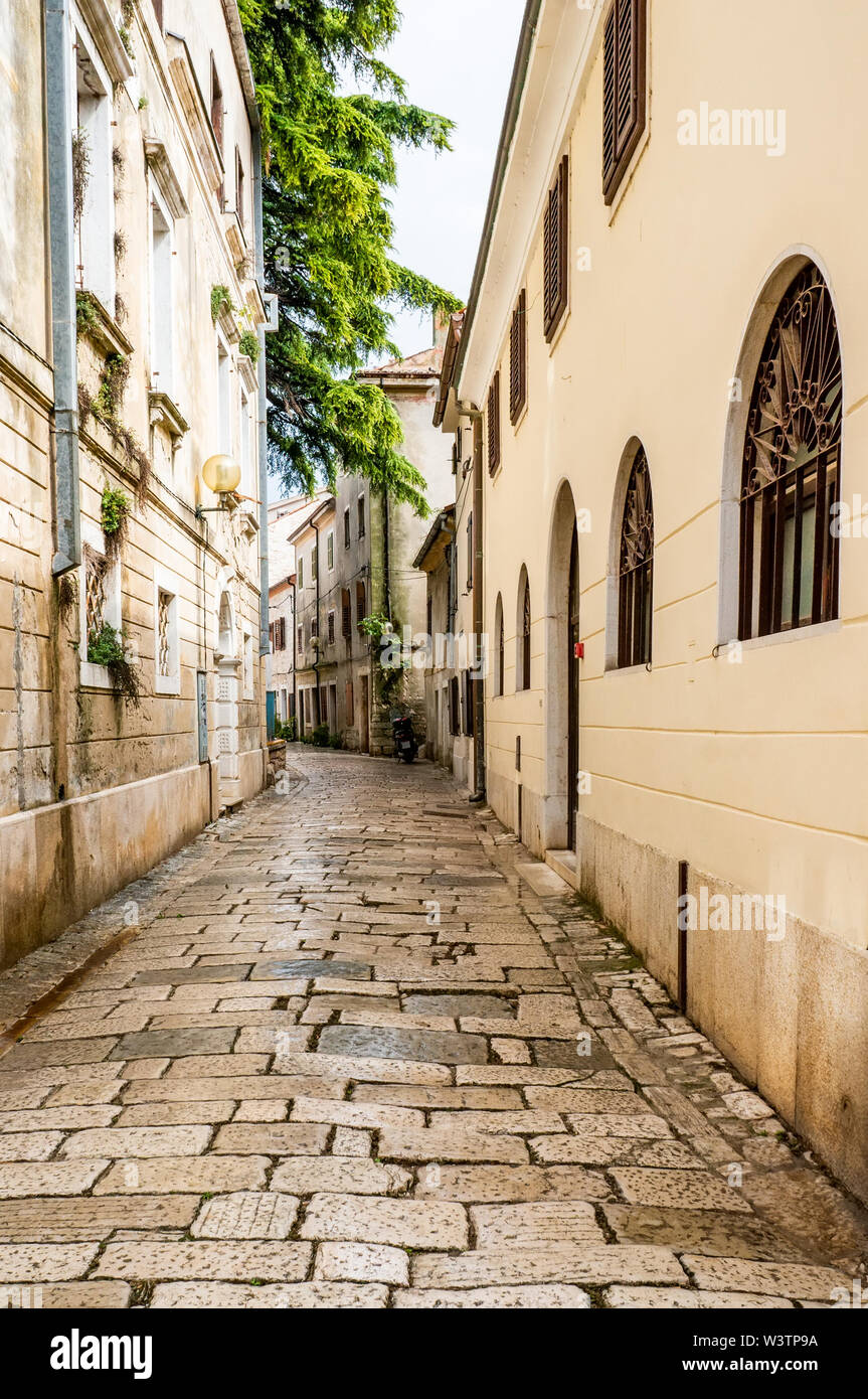 A typical narrow European street with a cobbled pavement. Croatia, the ...