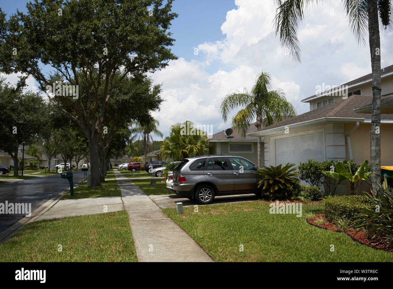 sun shining on concrete footpath sidewalk through gated community in ...